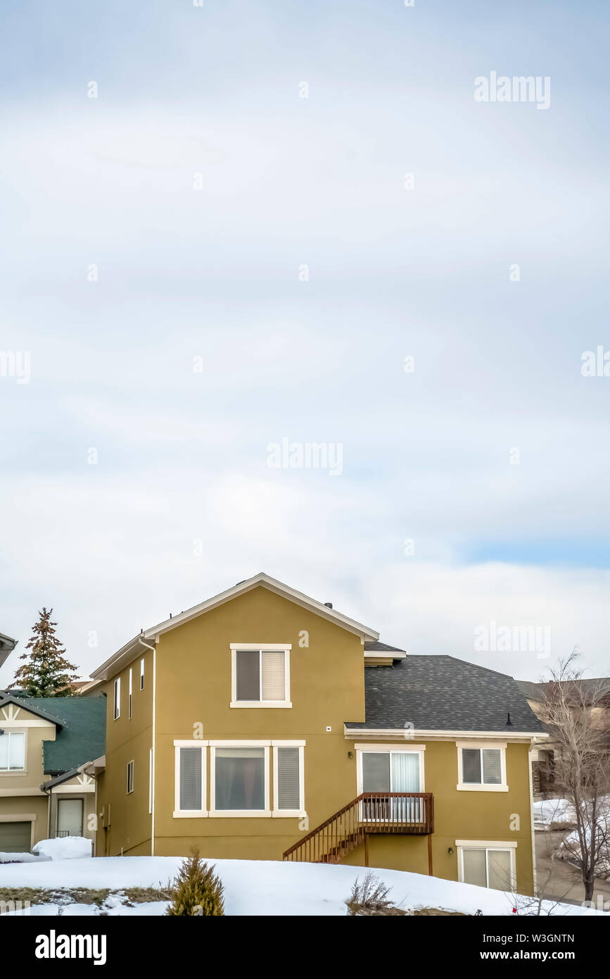 Home facade with stairs leading to the small balcony with overcast sky ...