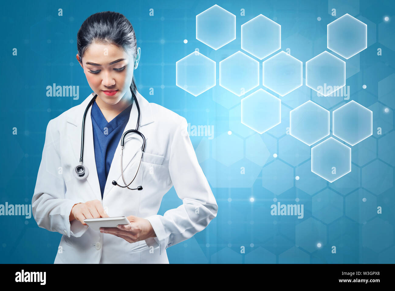 Asian woman doctor in white lab coat and stethoscope using tablet with ...