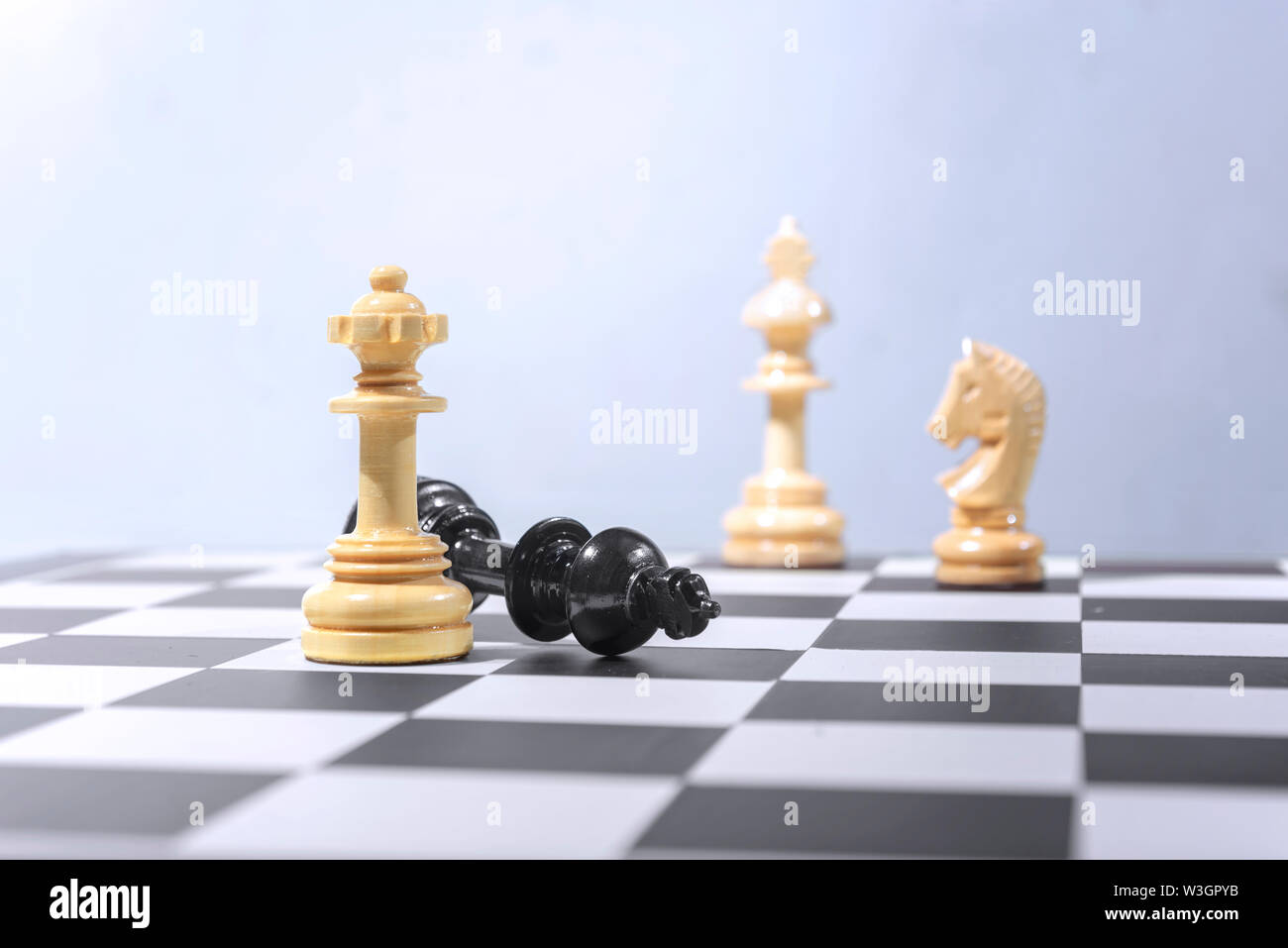 Black king chess piece defeated by wooden queen chess piece on the ...