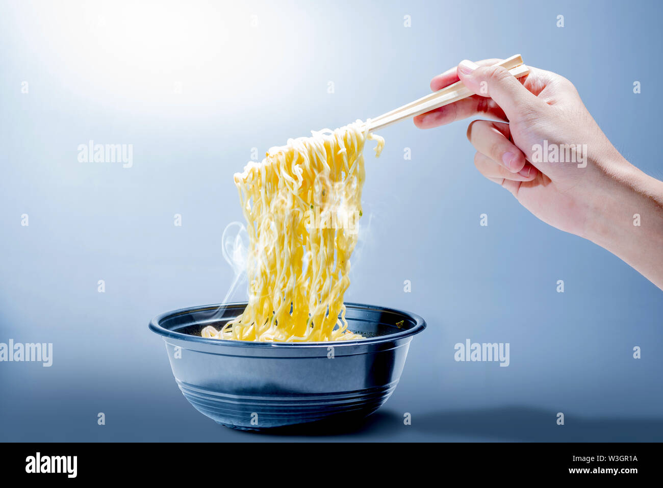 People eat the noodles with chopstick over bright background Stock ...