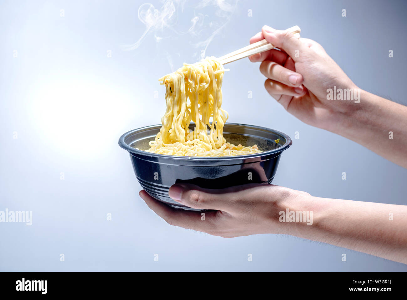 People eat the noodles with chopstick over bright background Stock ...