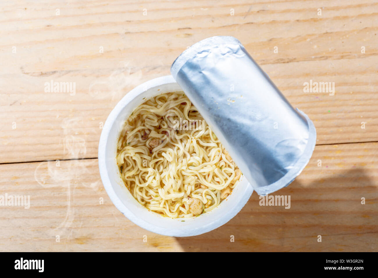Instant cup noodle on wooden table background Stock Photo - Alamy