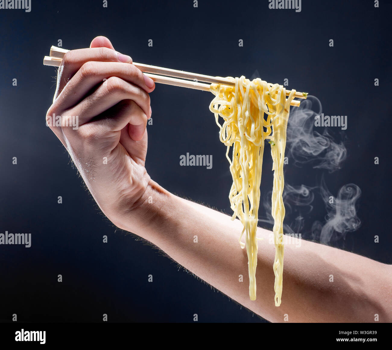 People eat the noodles with chopsticks over black background Stock ...