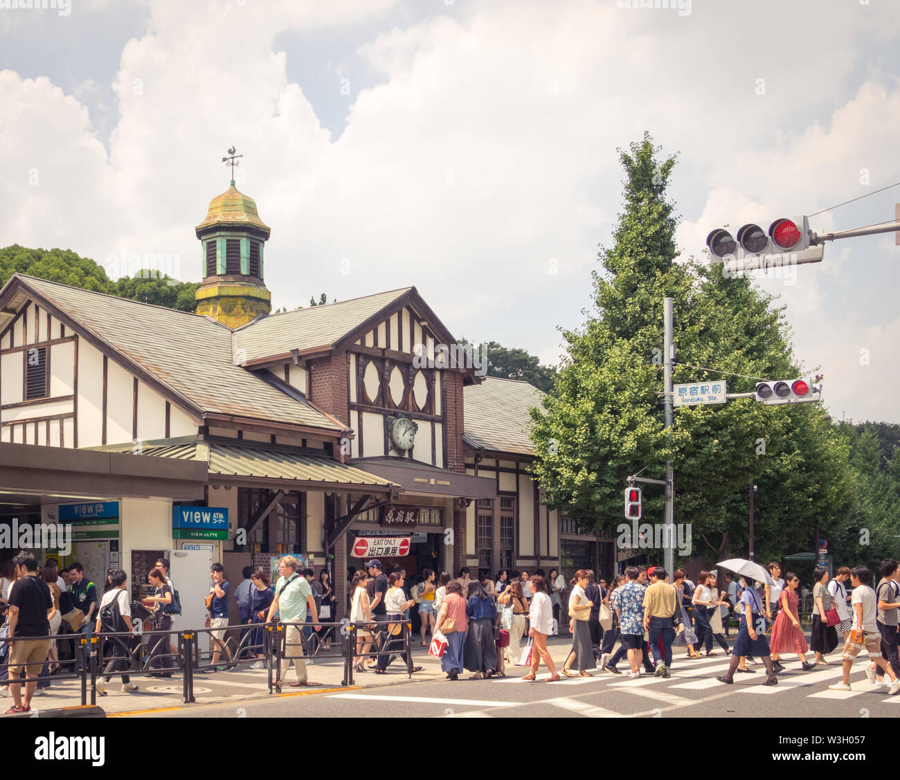 People and crowds outside of the busy Harajuku Station building, a ...