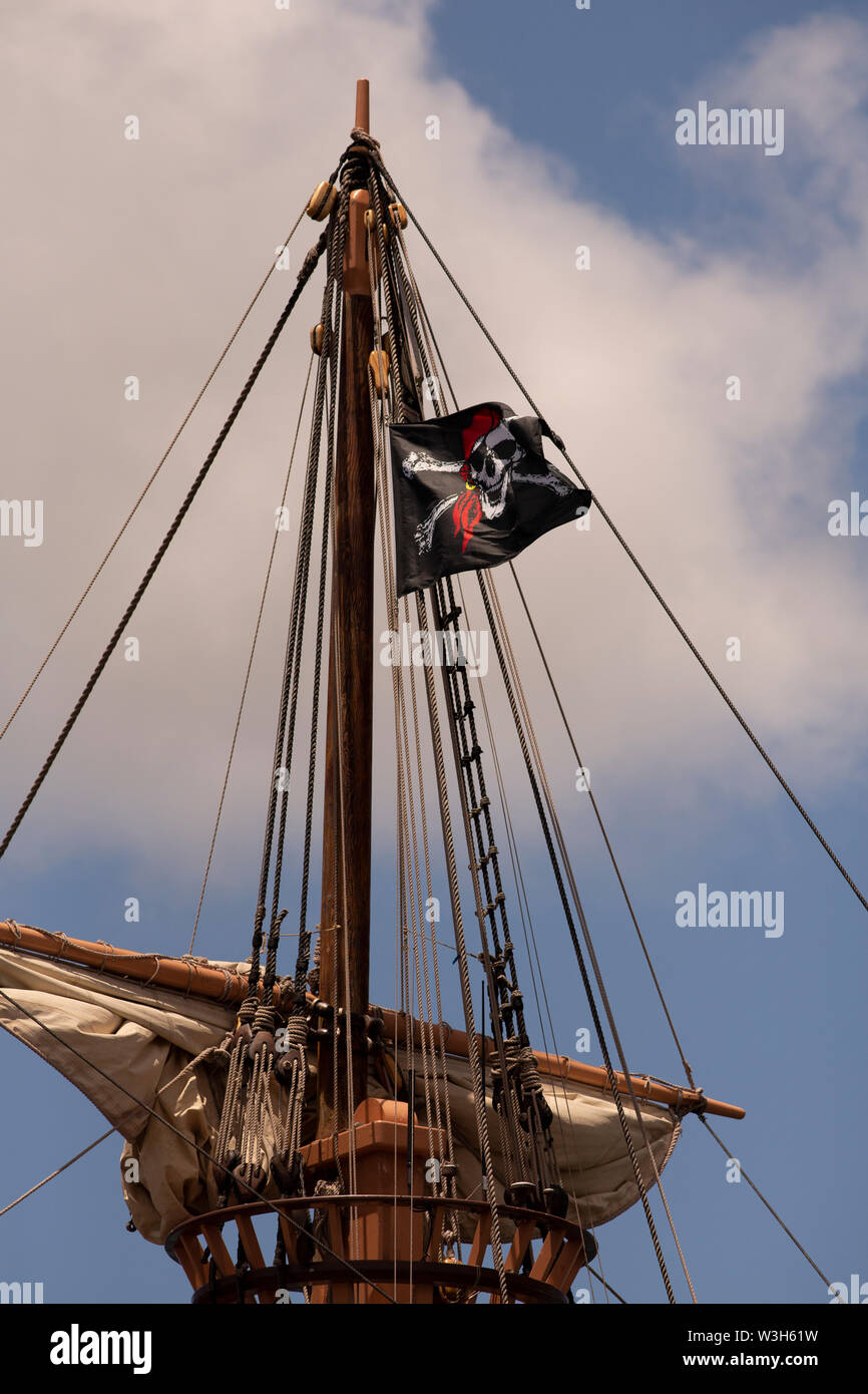 Mast with rigging and Pirate flag waving in the breeze Stock Photo - Alamy