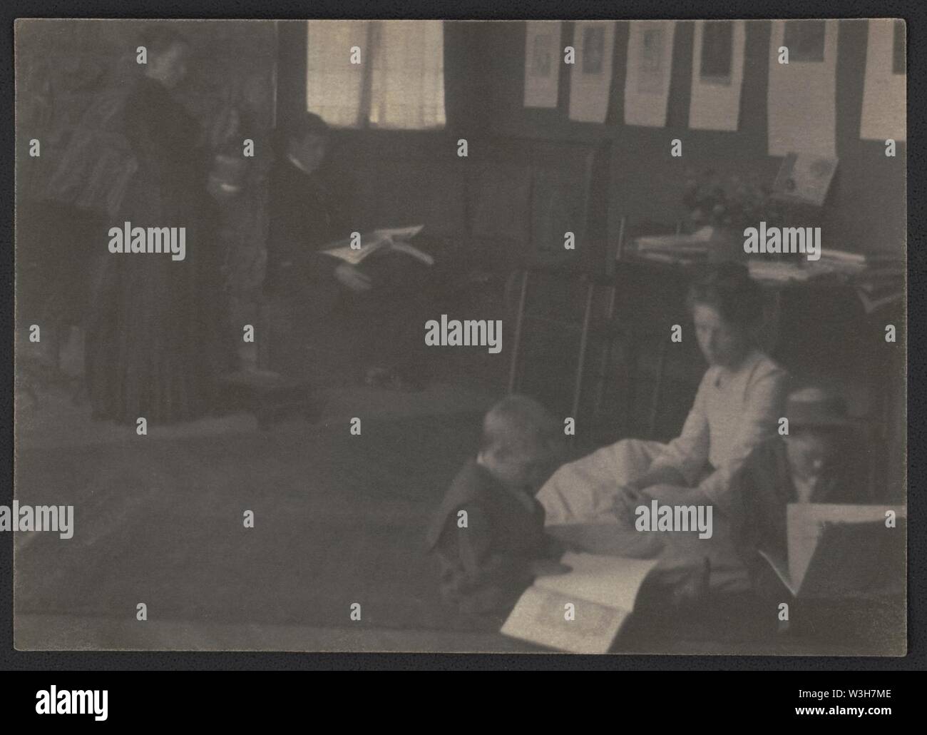 Clarence H. White and family reading in Newark parlor or dining room ...