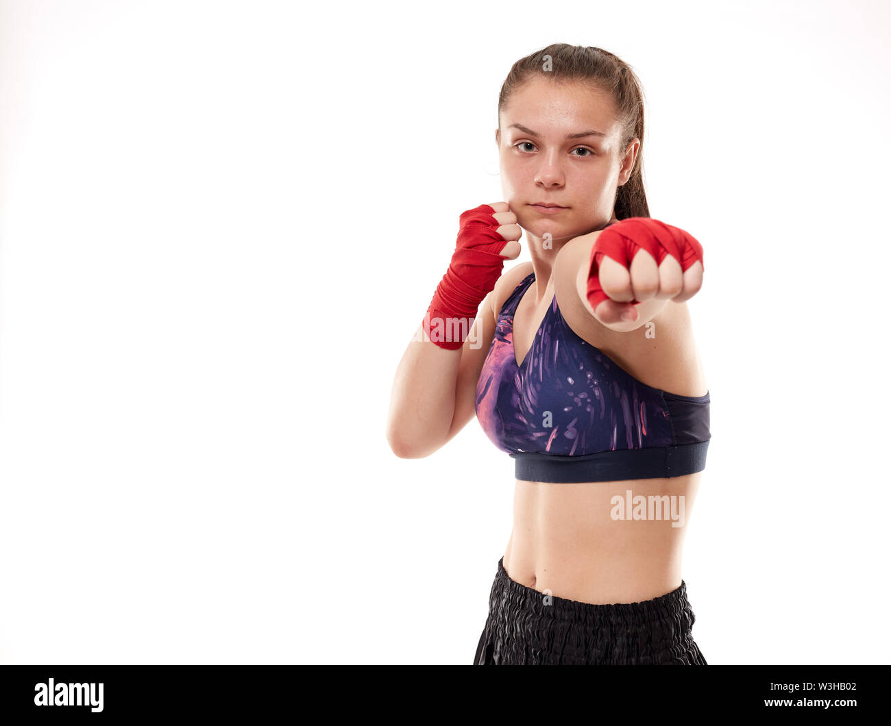 Young girl kickboxing fighter training, isolated on white background ...