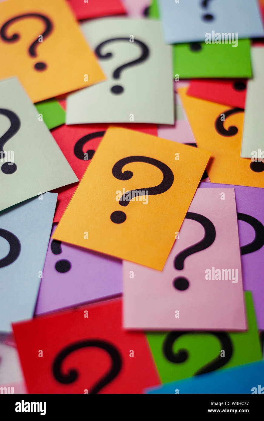 Colorful cards with printed question marks in a random scattered ...