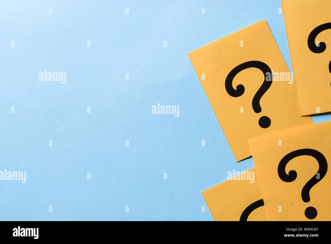Printed question marks on yellow paper or card forming a right side ...