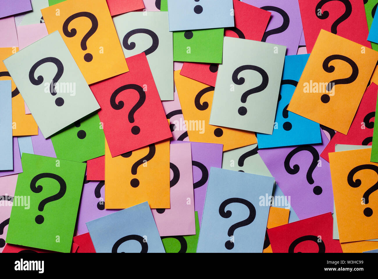 Background texture of multicolored paper printed with question marks ...