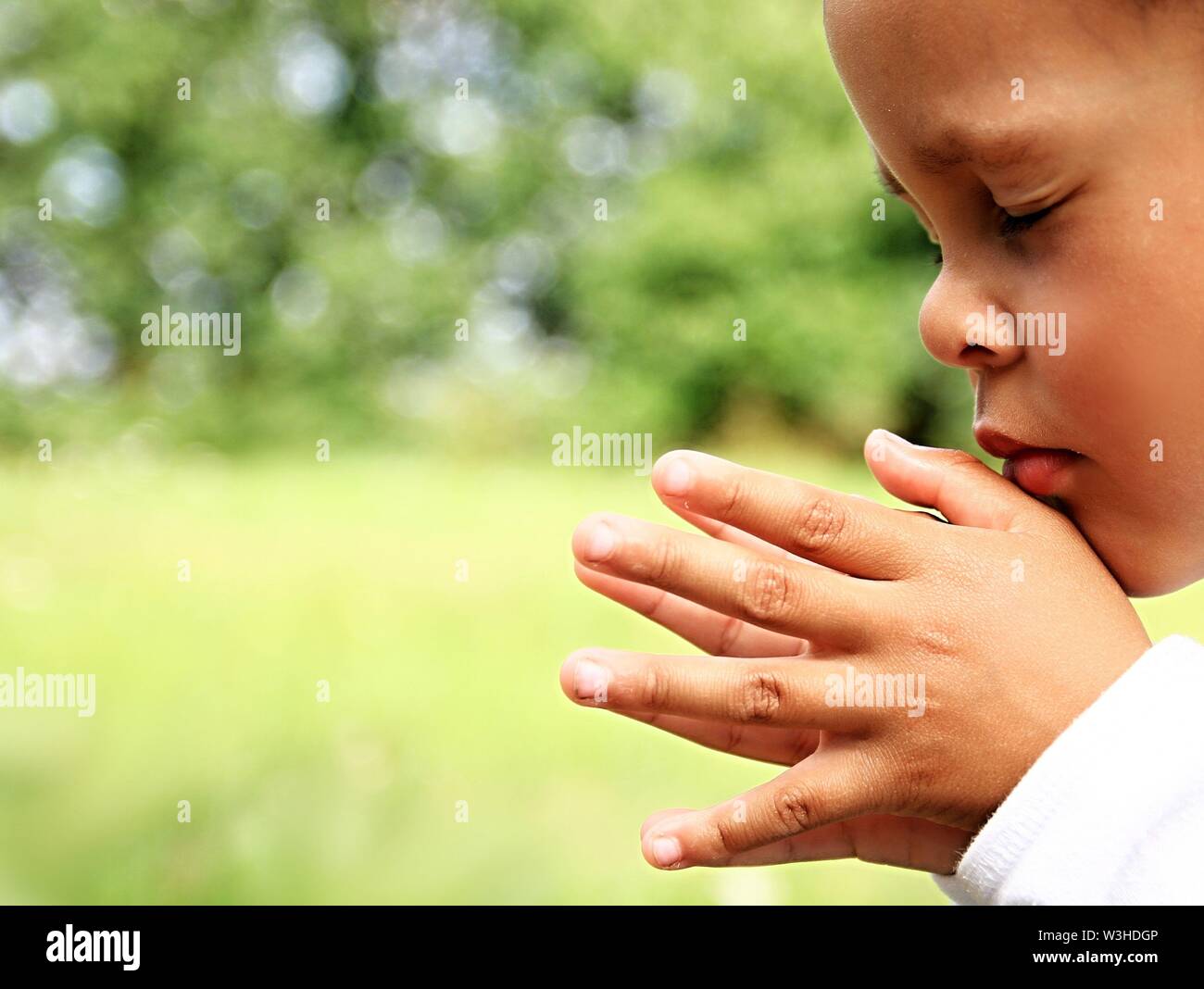 little boy praying to God and being religious stock image with hands ...