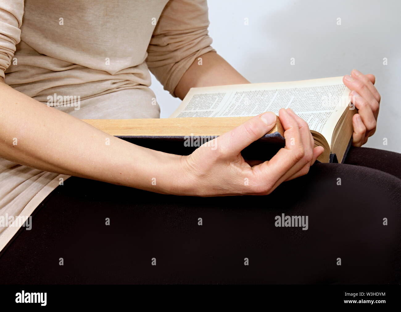 praying hands holding and reading the holy bible stock image and stock ...