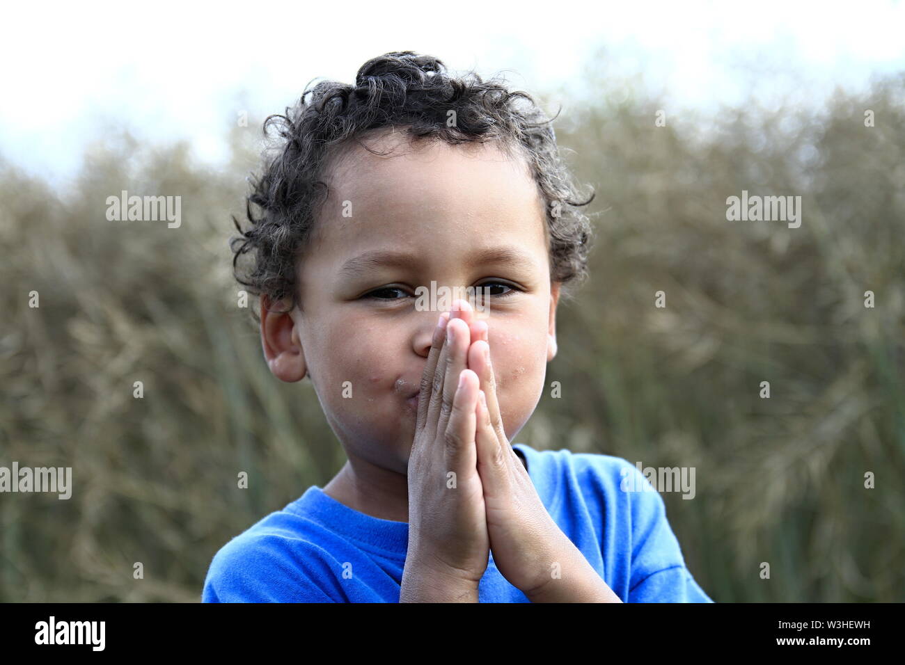 little boy praying to God and being religious stock image with hands ...