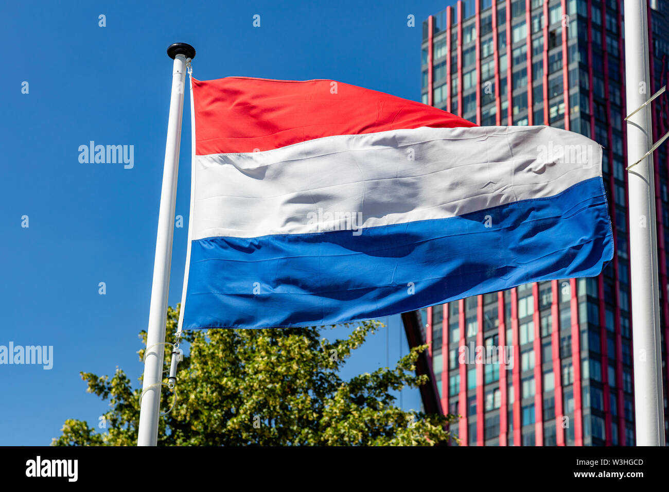 Netherlands flag. Dutch national symbol waving on pole against clear ...