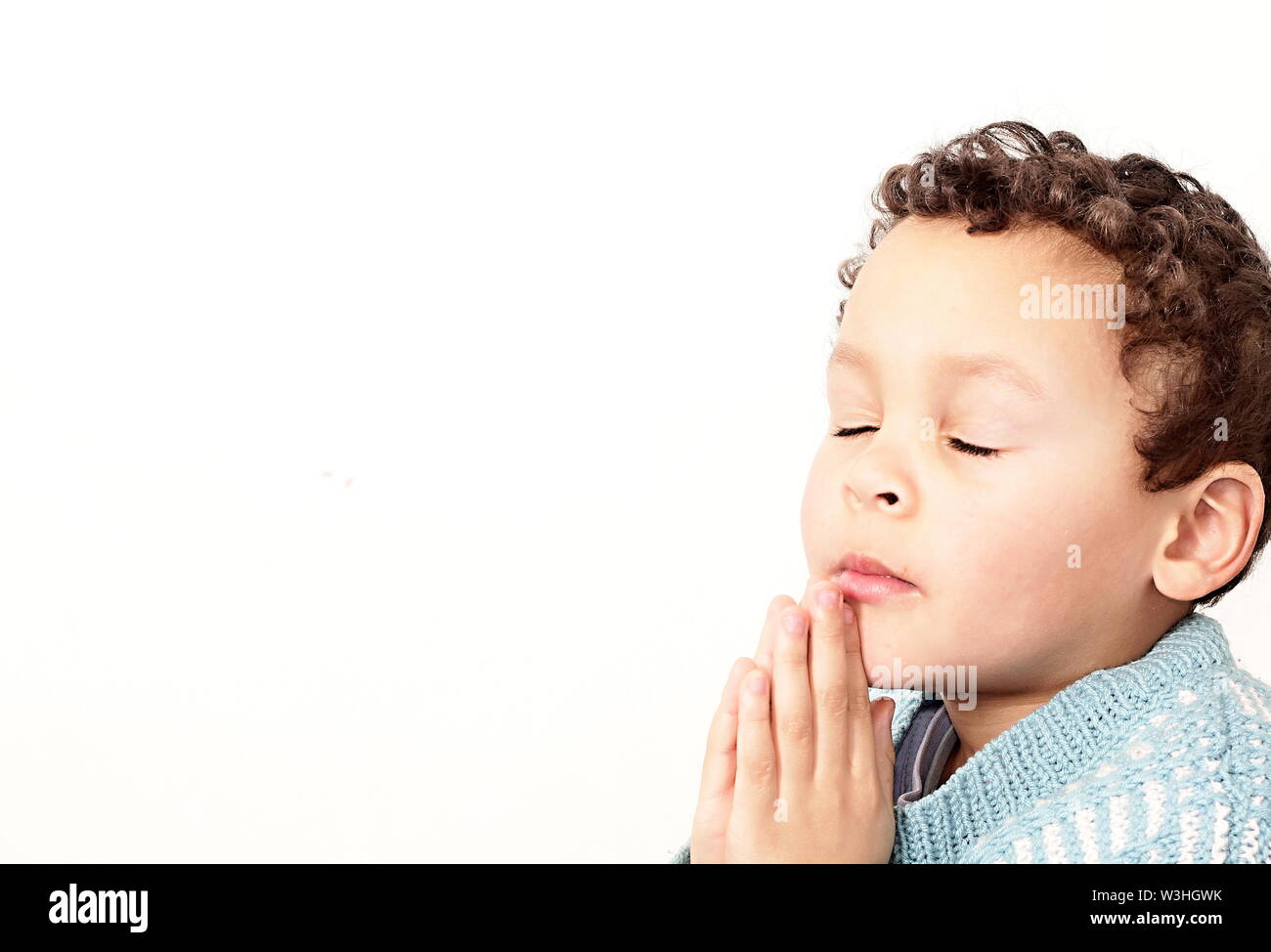little boy praying to God and being religious stock image with hands ...