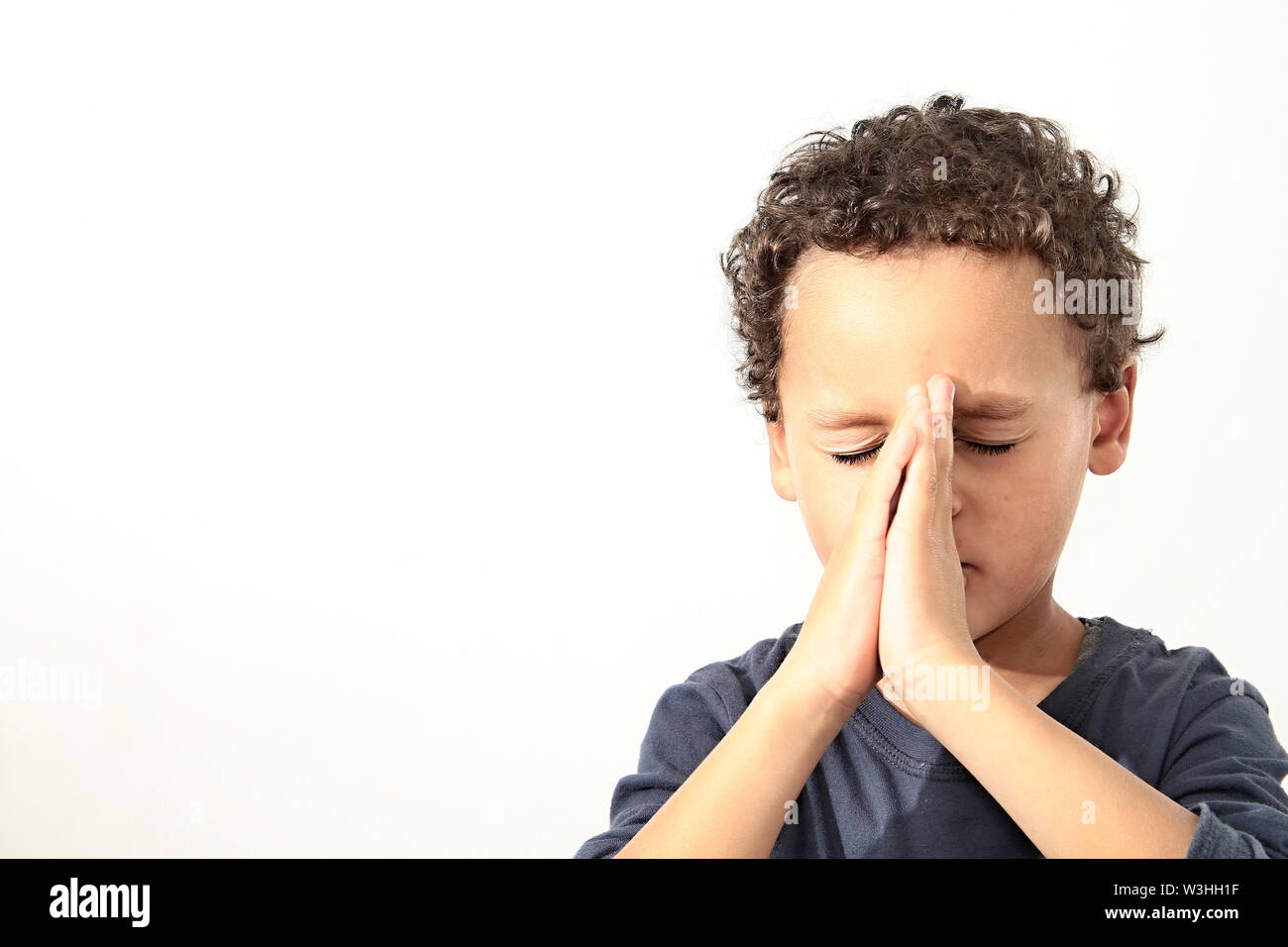 little boy praying to God and being religious stock image with hands ...