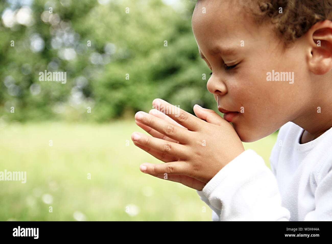little boy praying to God and being religious stock image with hands ...