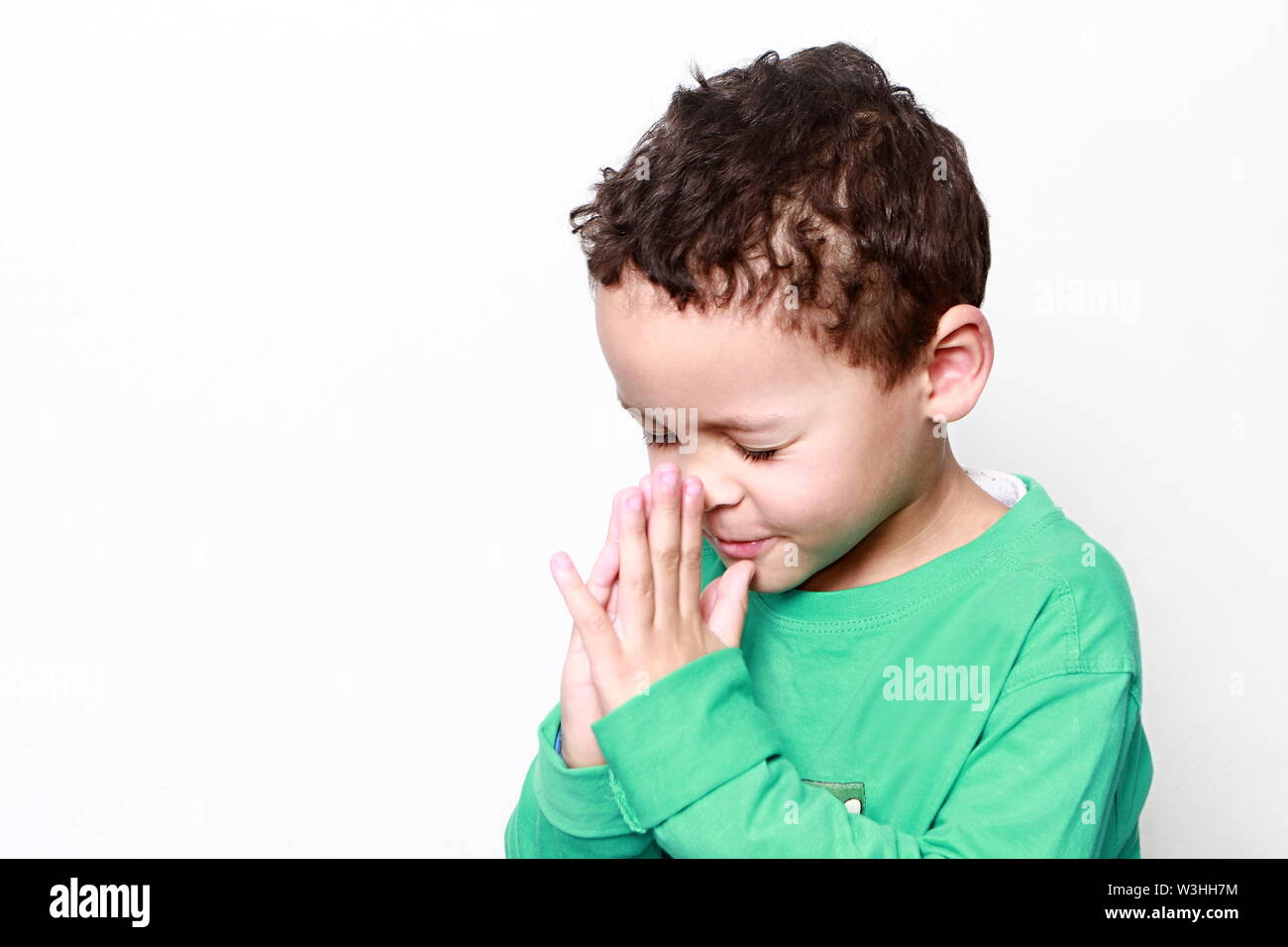 little boy praying to God and being religious stock image with hands ...