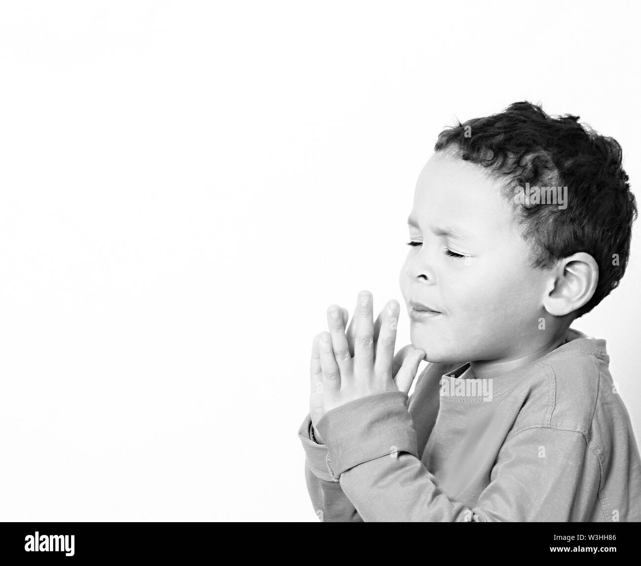 little boy praying to God and being religious stock image with hands ...