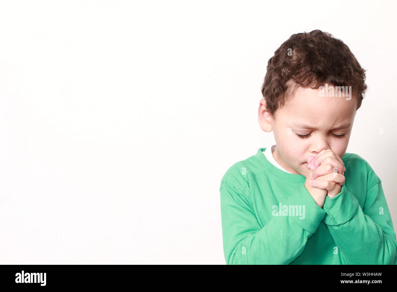 little boy praying to God and being religious stock image with hands ...