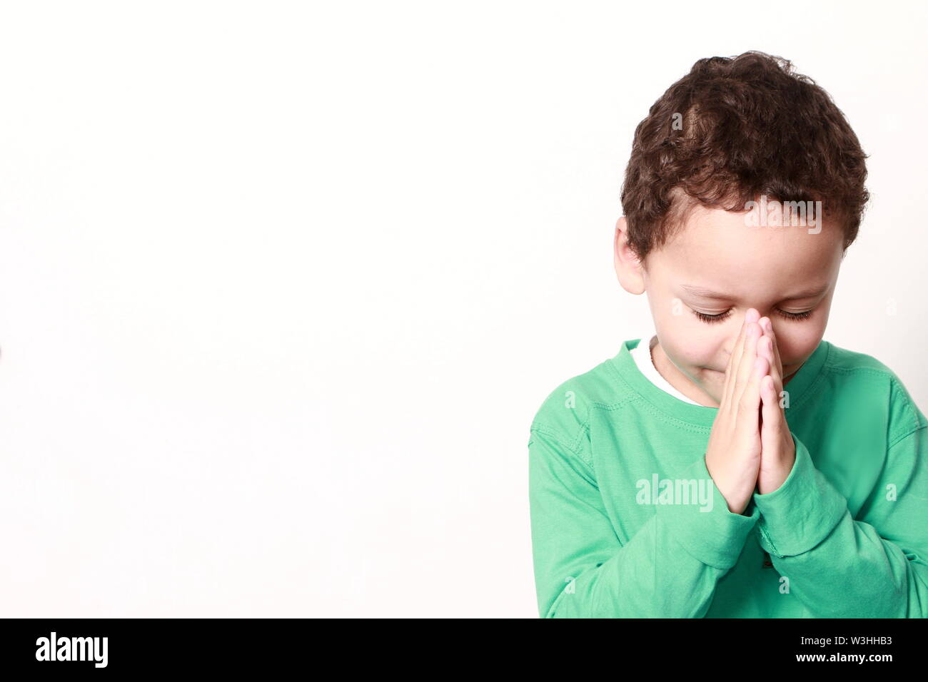 little boy praying to God and being religious stock image with hands ...