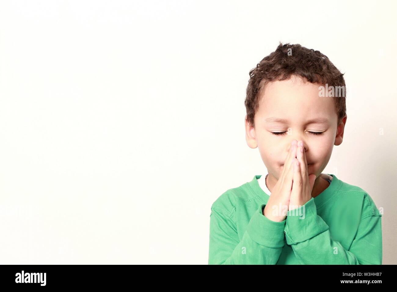 little boy praying to God and being religious stock image with hands ...