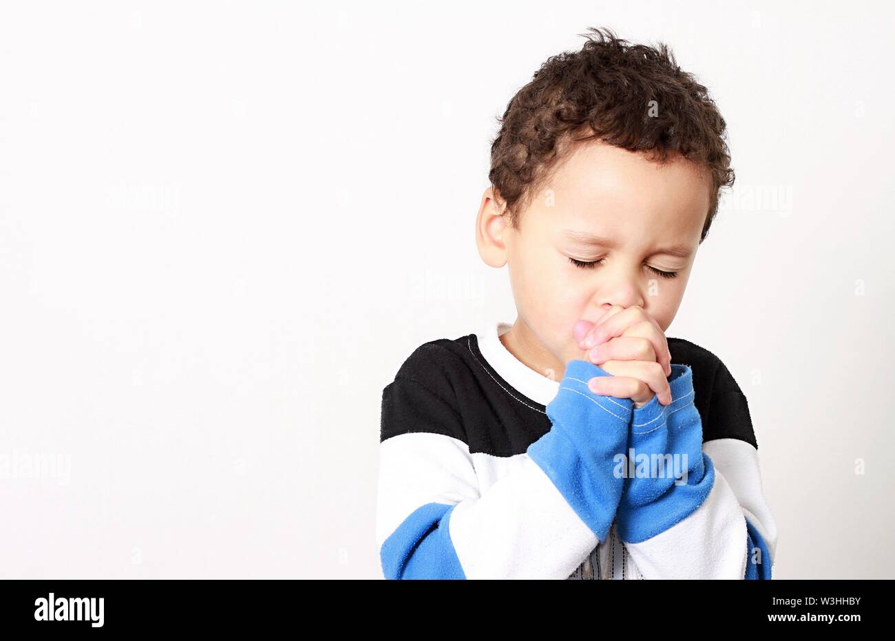 little boy praying to God and being religious stock image with hands ...