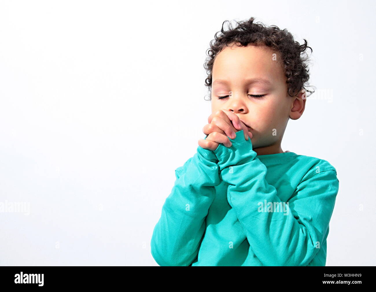 little boy praying to God and being religious stock image with hands ...