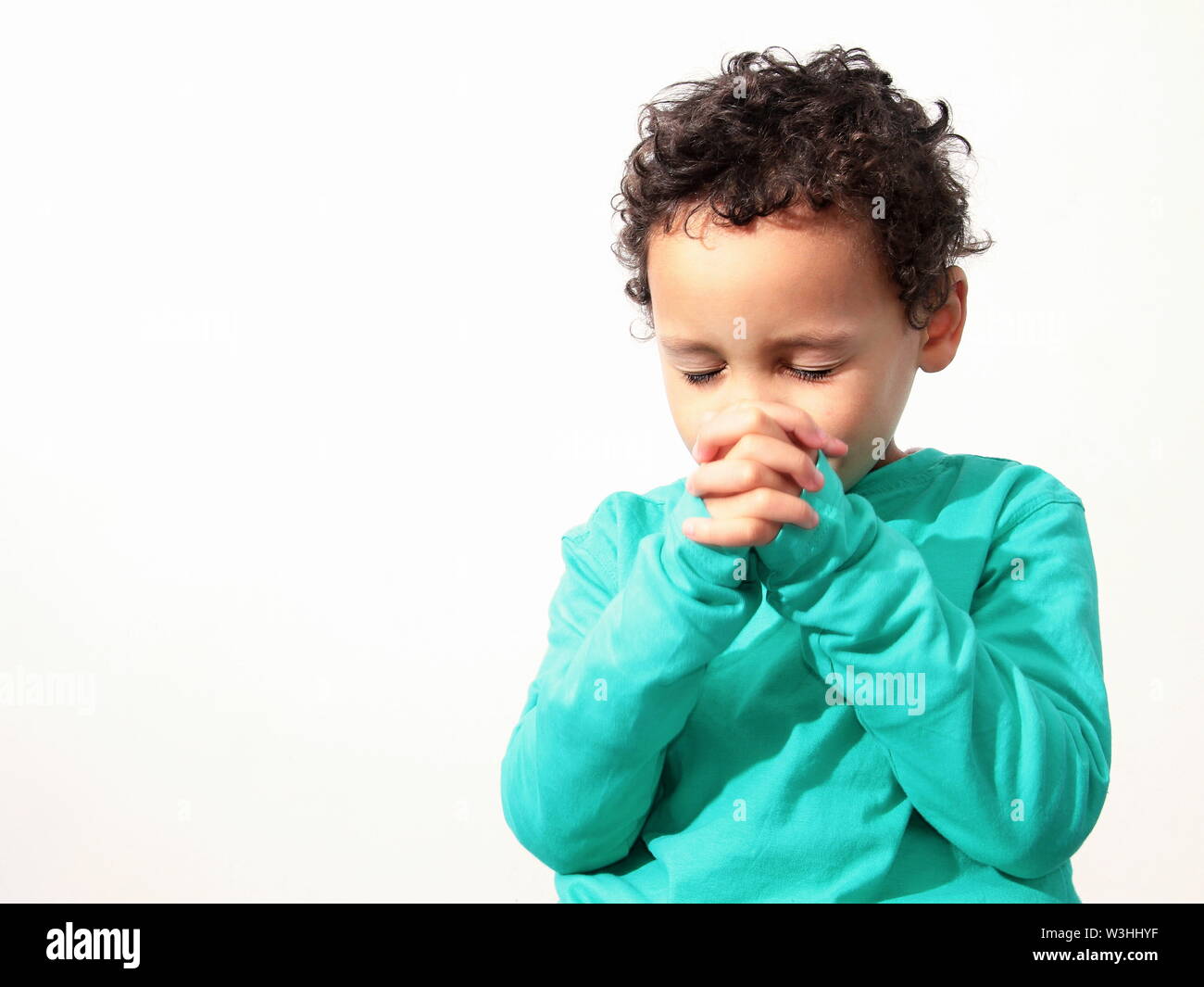 little boy praying to God and being religious stock image with hands ...