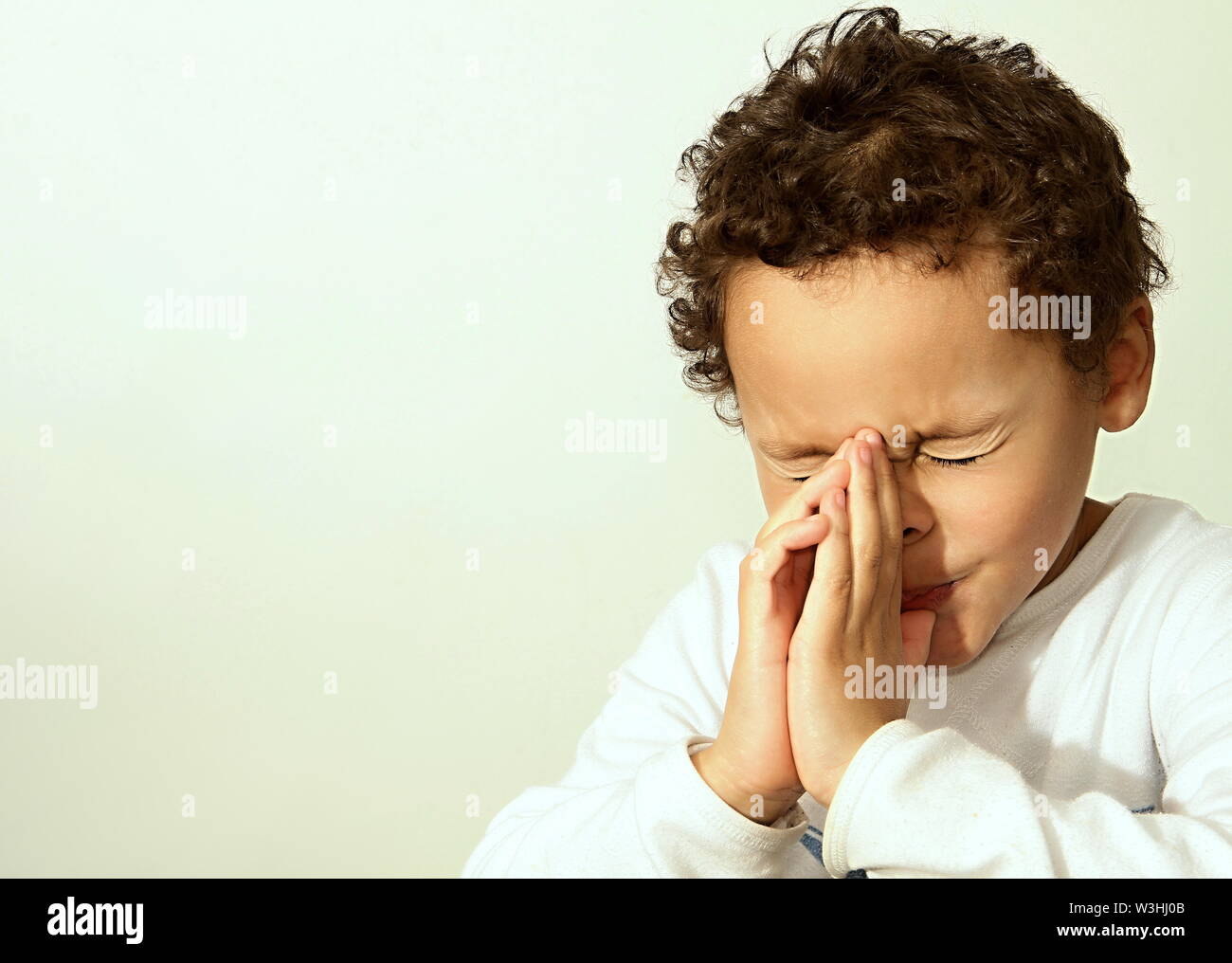 little boy praying to God and being religious stock image with hands ...