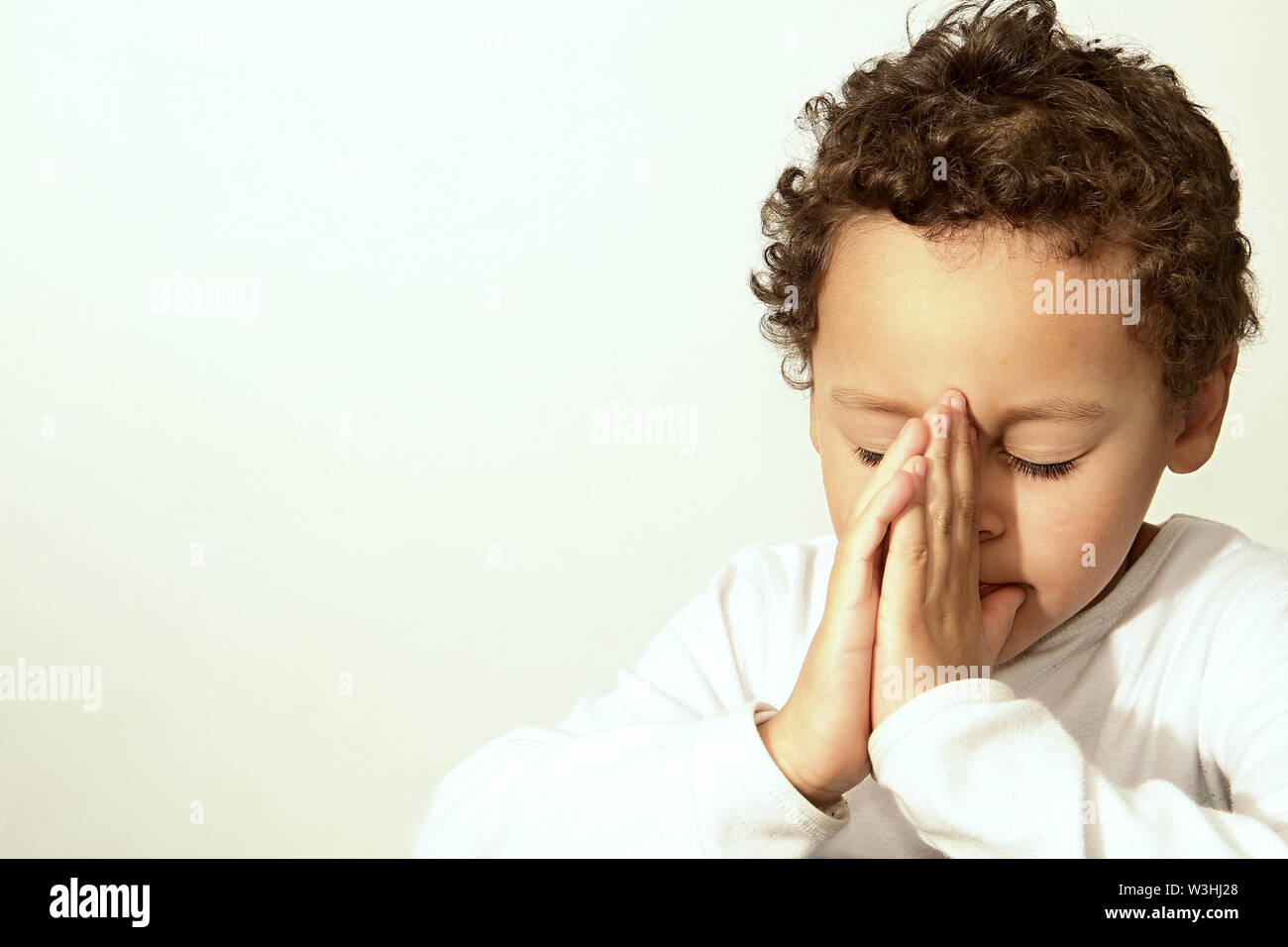 little boy praying to God and being religious stock image with hands ...