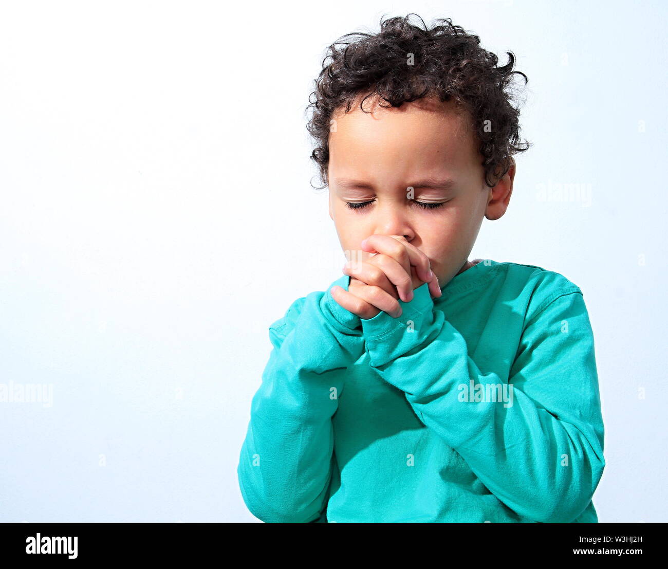 little boy praying to God and being religious stock image with hands ...