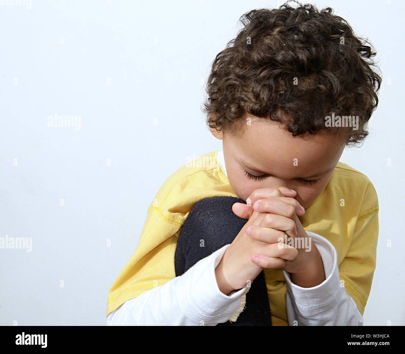 little boy praying to God and being religious stock image with hands ...