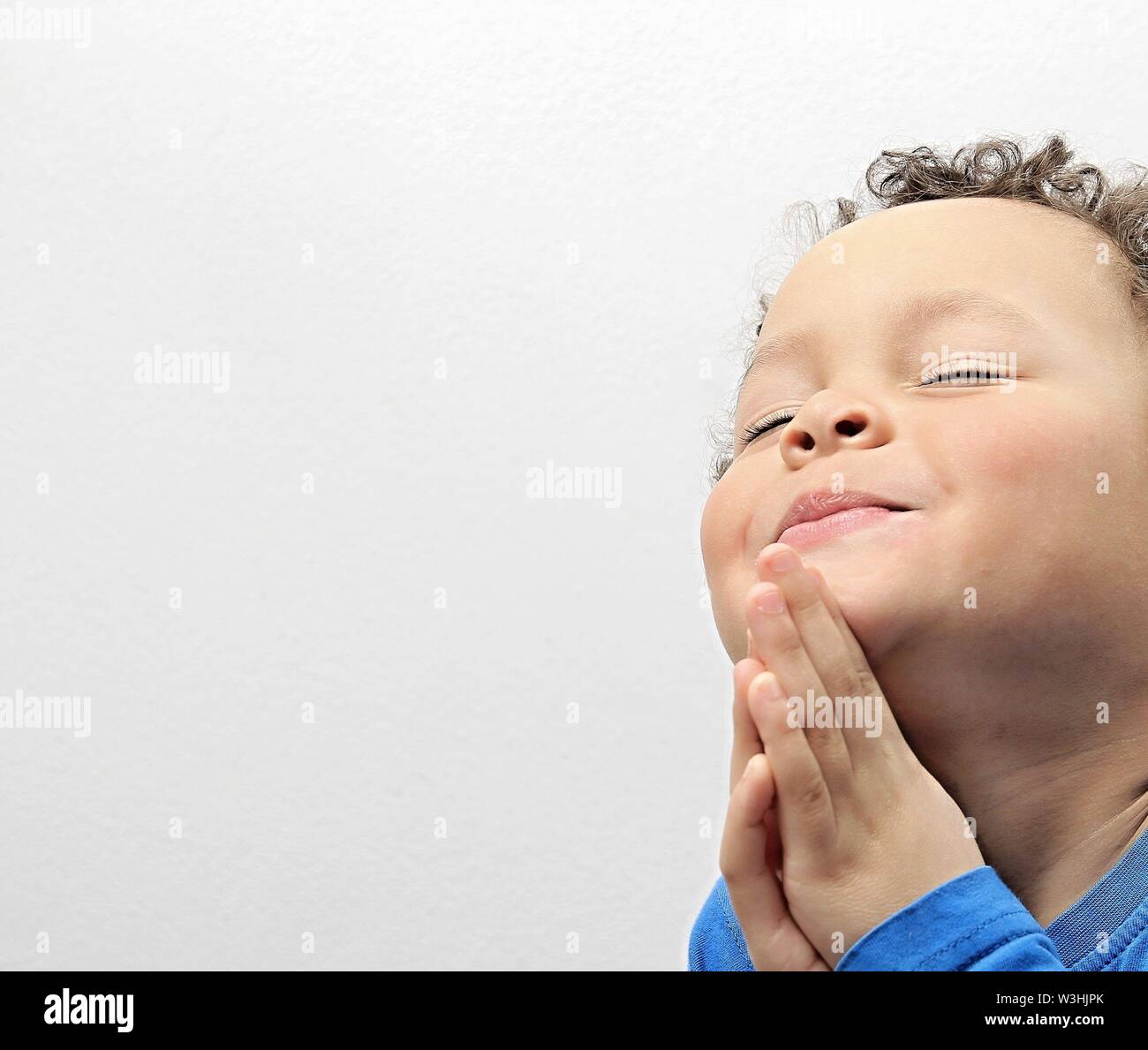 little boy praying to God and being religious stock image with hands ...