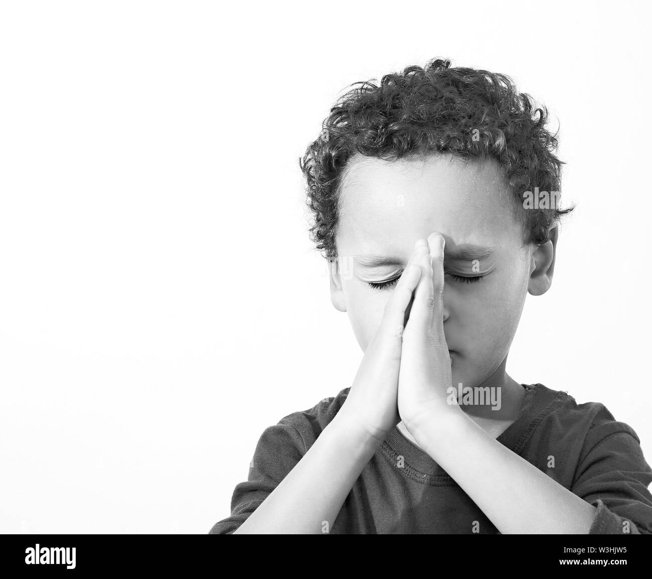 little boy praying to God and being religious stock image with hands ...