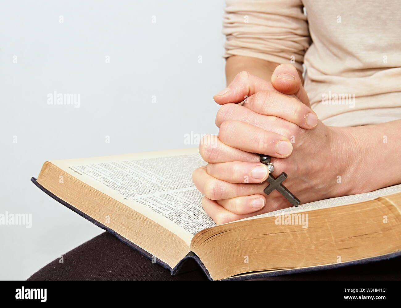 praying hands holding and reading the holy bible stock image and stock ...