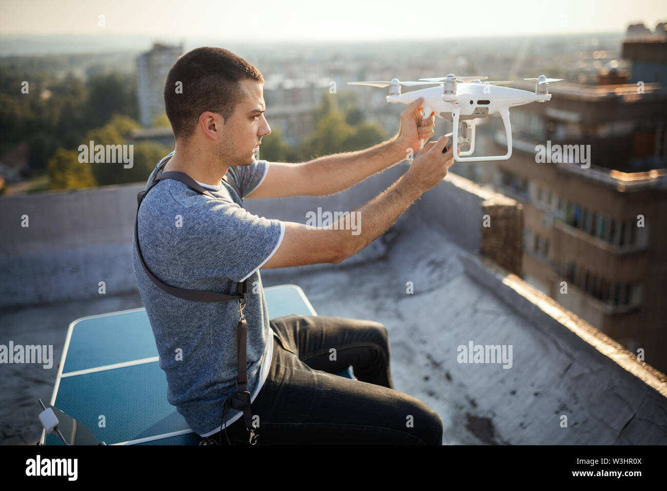Man operating a drone with remote control on rooftop Stock Photo - Alamy