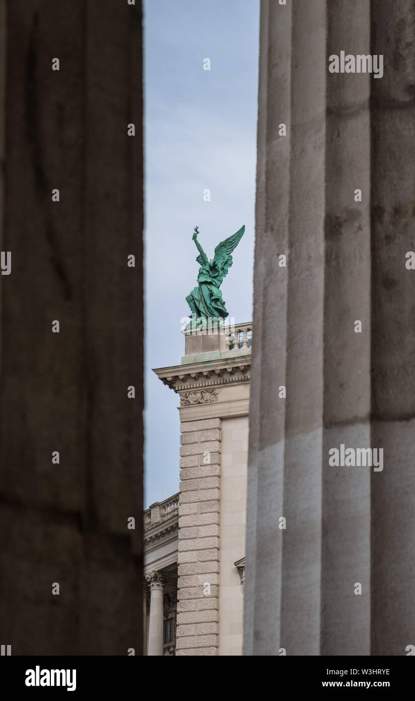 Winged sculpture seen through building columns, Hofburg, Vienna ...