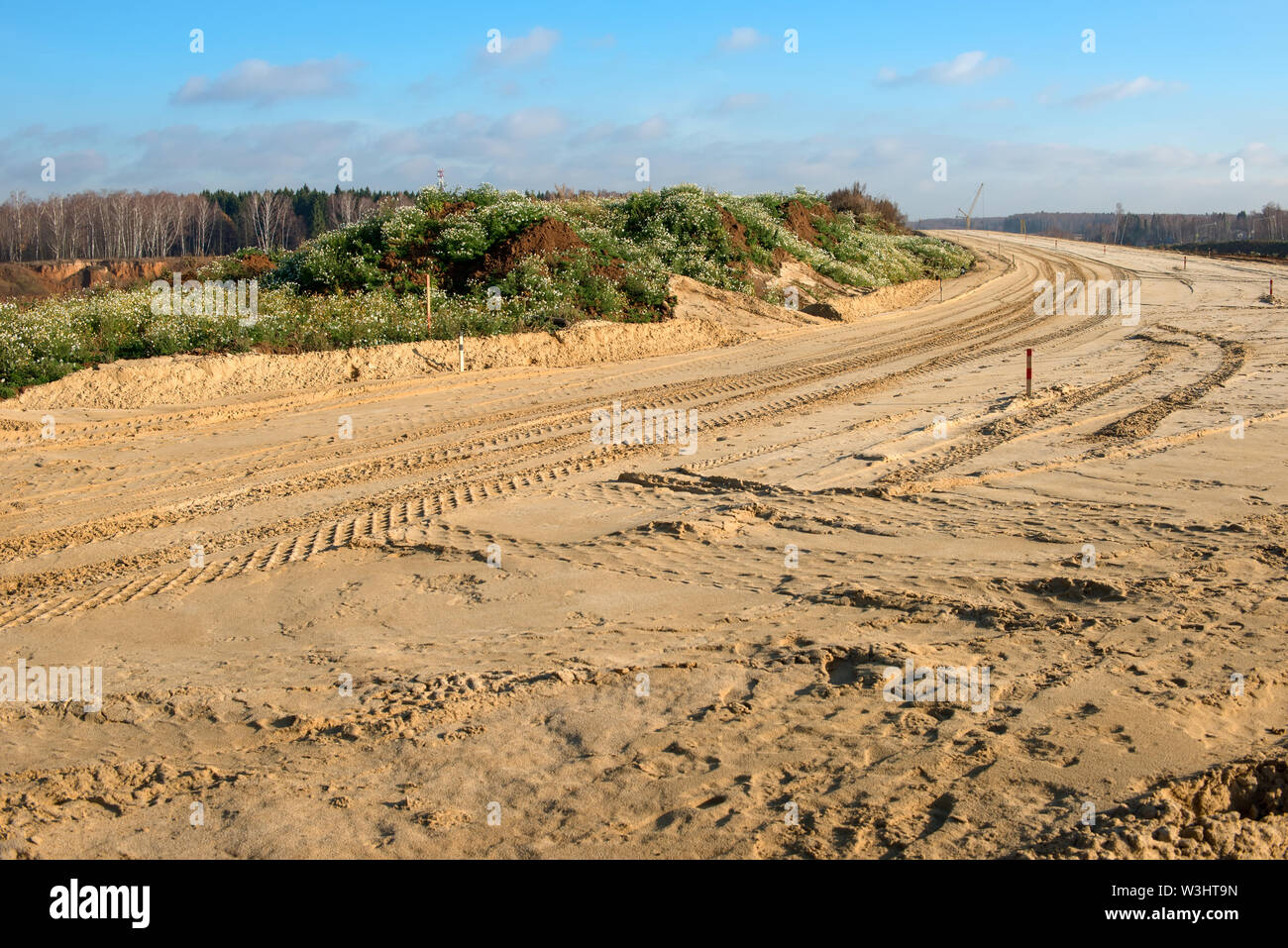 Construction of a new road. The marked space is covered with sand and ...