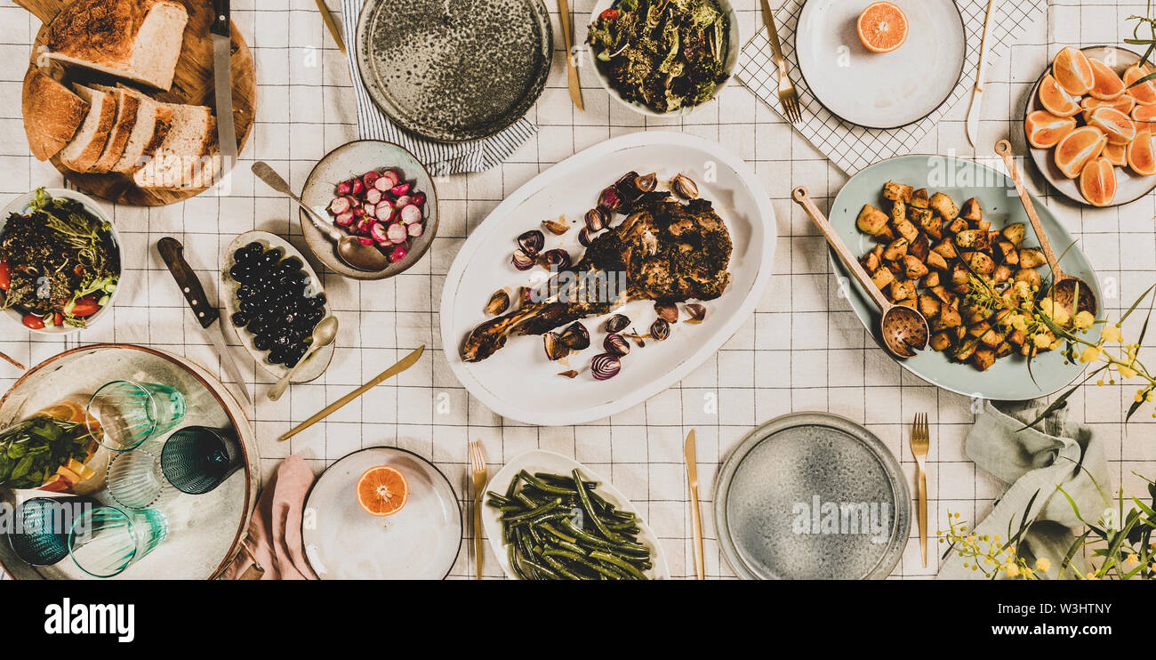 Family, friends gathering dinner. Flat-lay of roasted lamb shoulder ...