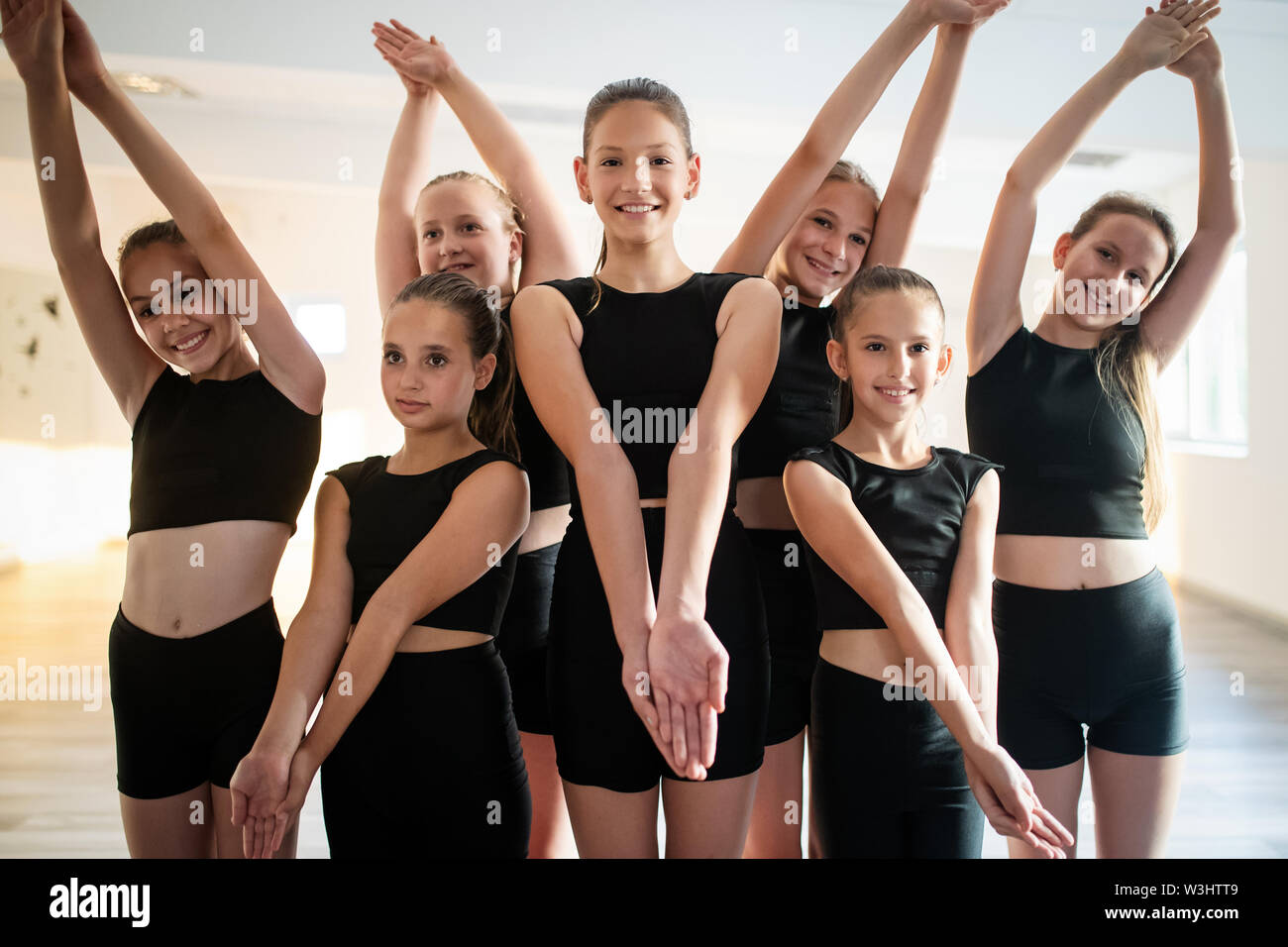 Group of fit happy children exercising dancing and ballet in studio ...