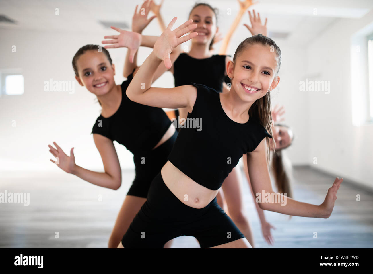 Group of fit happy children exercising ballet and dancing in studio ...
