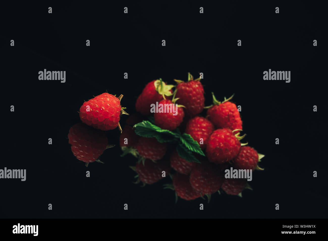 Beautiful fresh raspberry on a black glass table dark background Stock ...