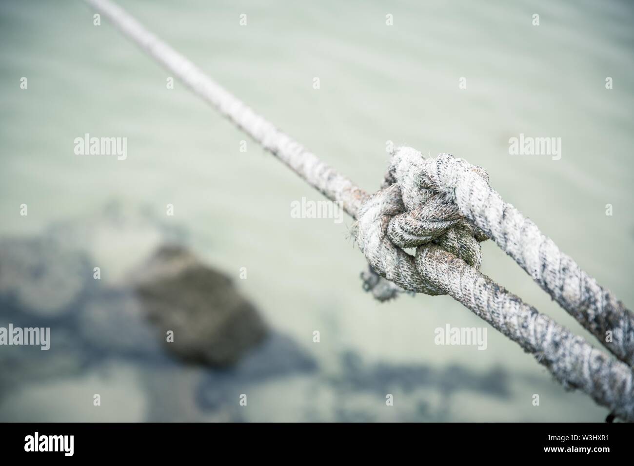 Closeup of a tightly tied up knot with a white rope tied by a fisherman ...