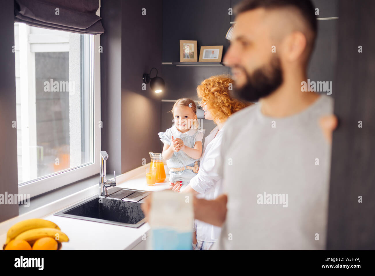 Sweet child. Delighted cute girl smiling while being held by her mother ...