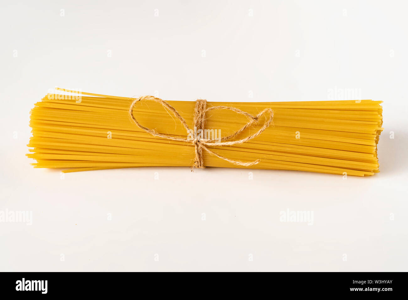 roped or tied bunch od dry uncooked spaghetti isolated on white surface ...