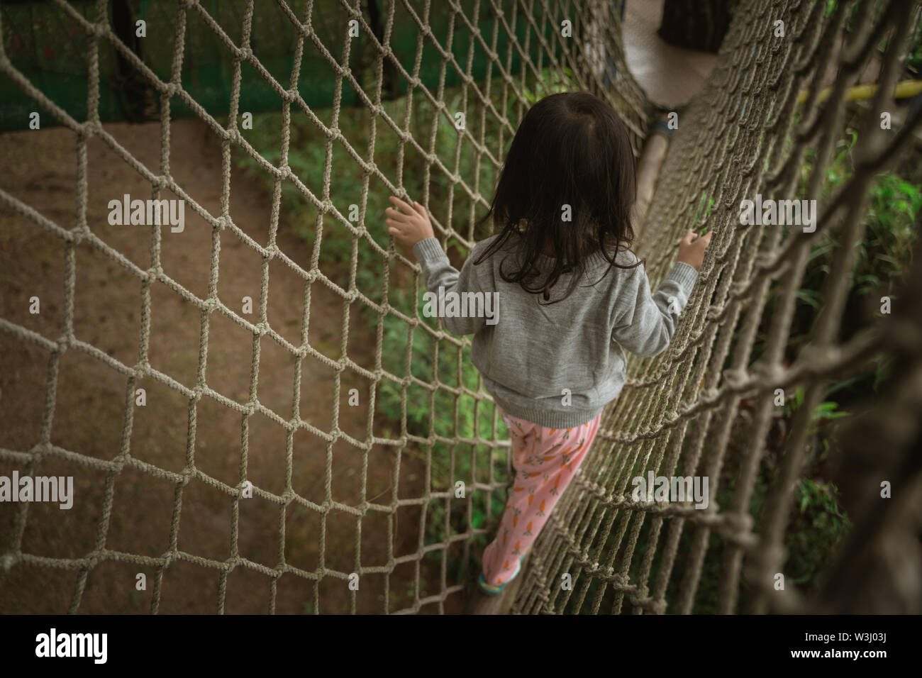 young asian kid playing on outdoor playground in nature crossing ...