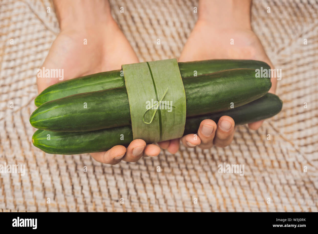 Eco-friendly product packaging concept. Cucumber wrapped in a banana ...