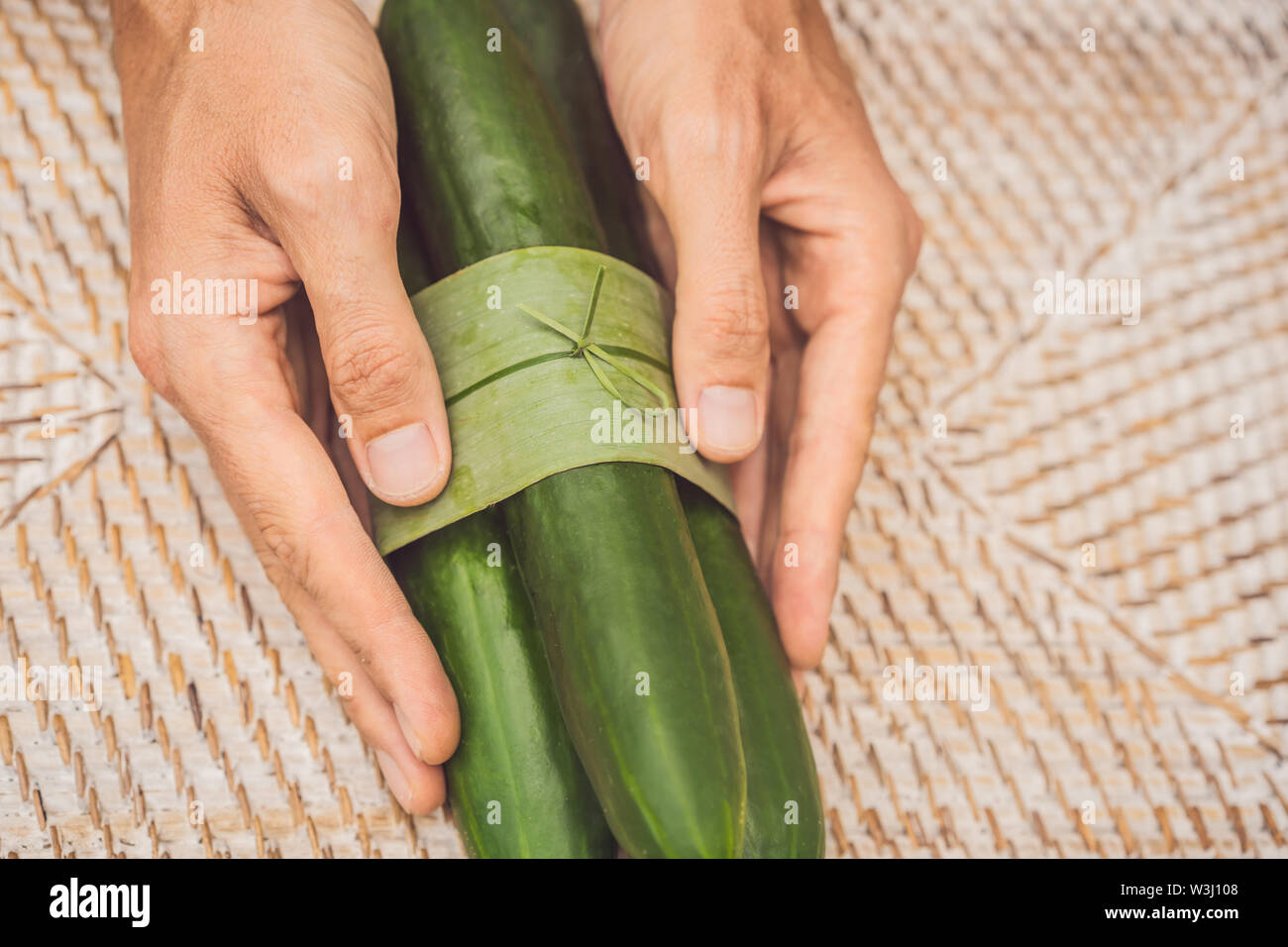 Eco-friendly product packaging concept. Cucumber wrapped in a banana ...