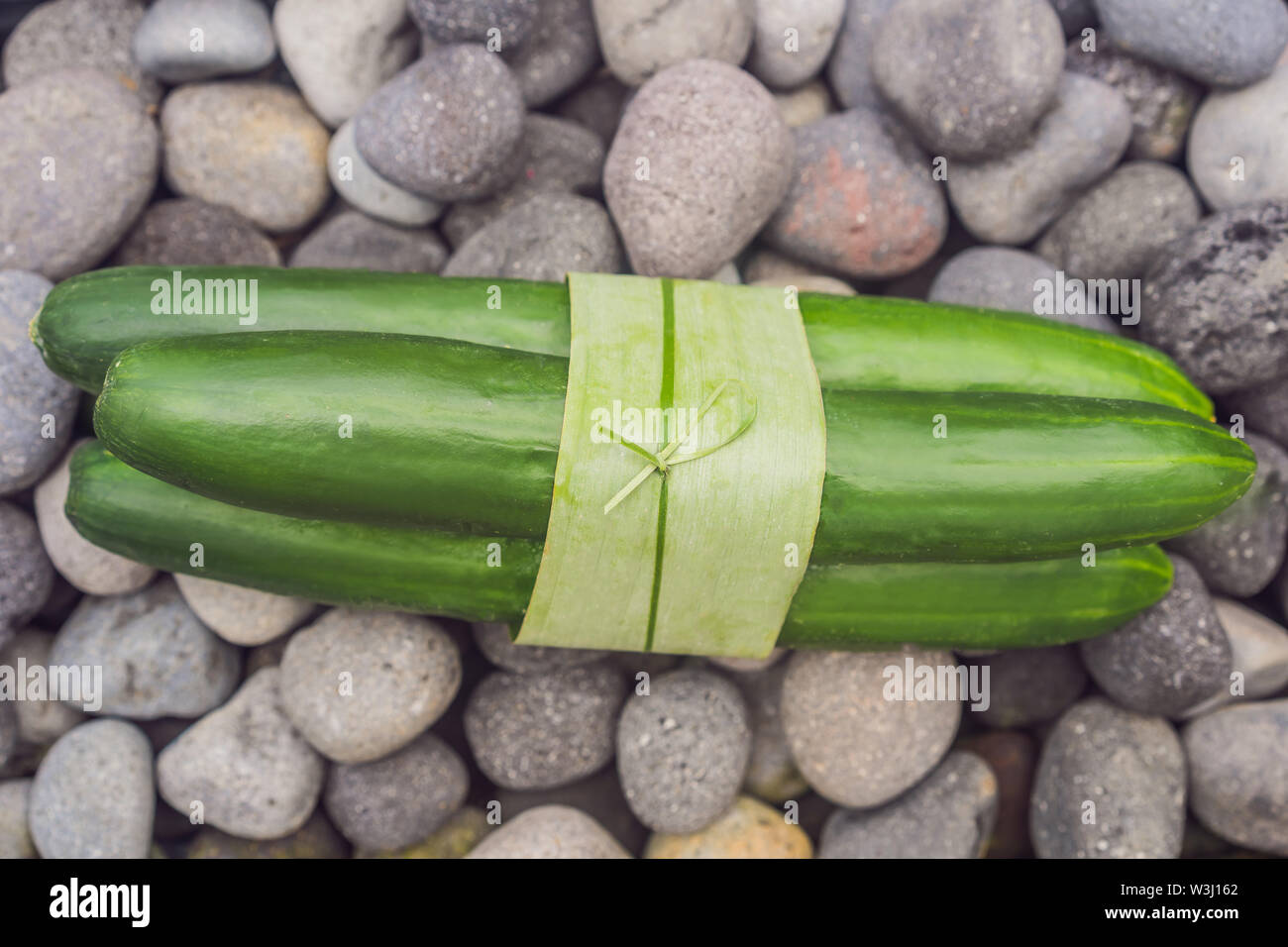 Eco-friendly product packaging concept. Cucumber wrapped in a banana ...